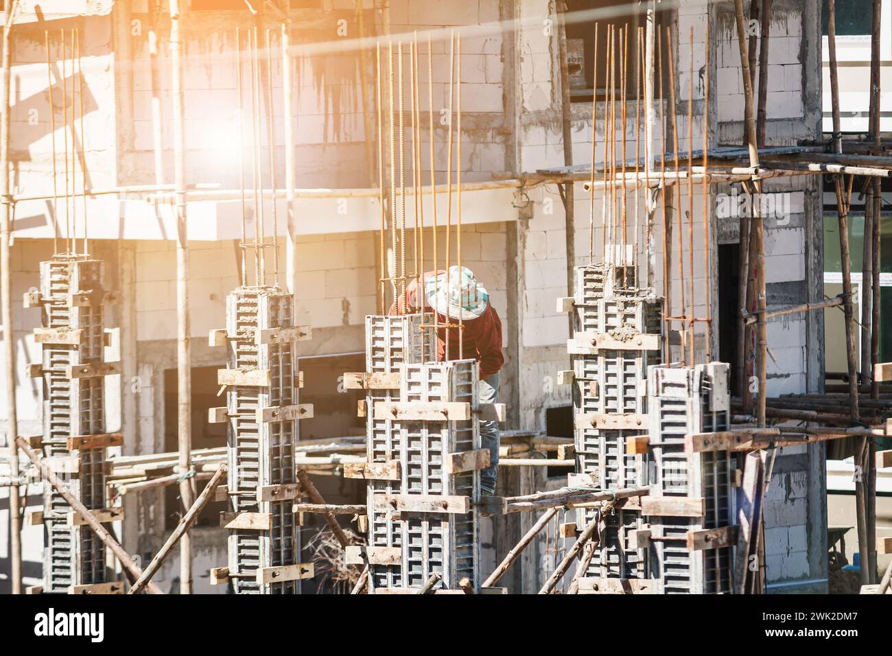 Worker pouring concrete to formwork frames at construction site to ...