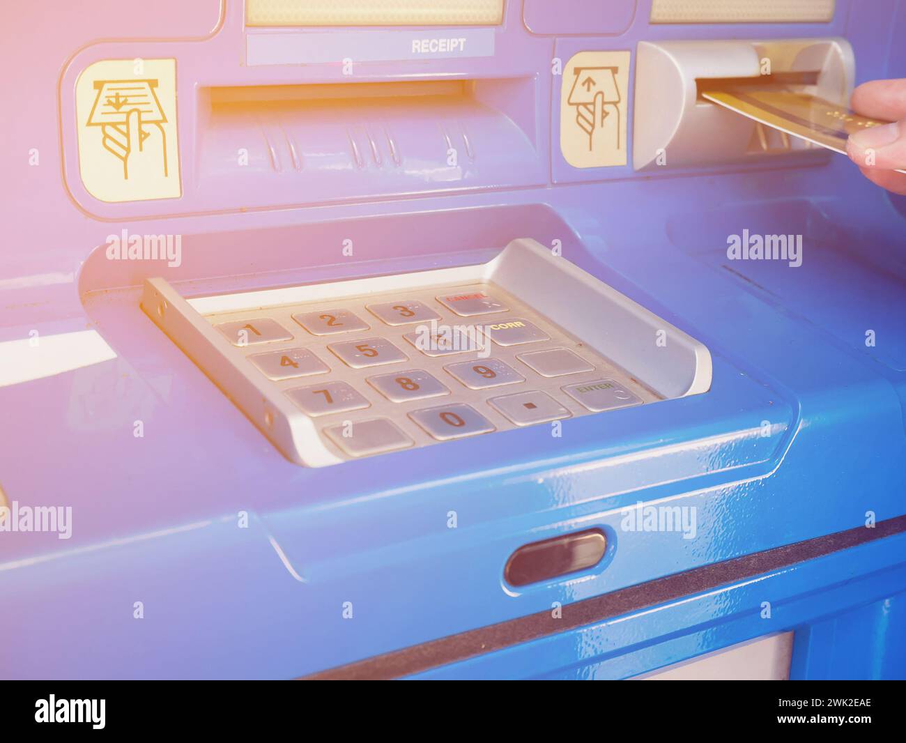 female hand inserting ATM card into ATM bank machine to withdraw money ...