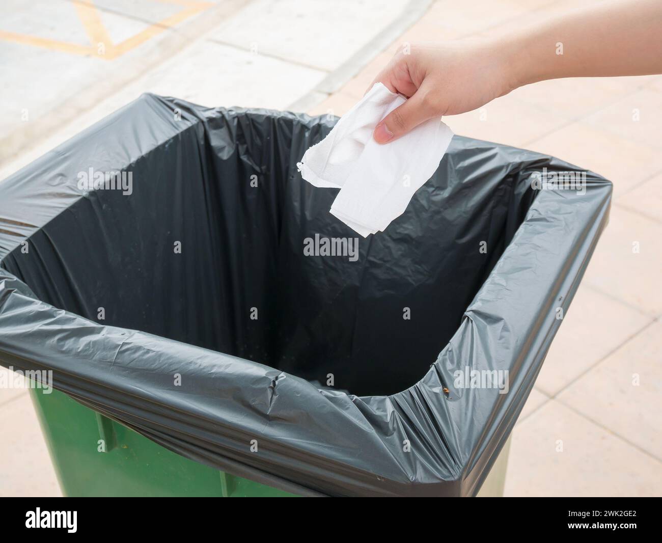 hand putting paper into trash bin Stock Photo - Alamy