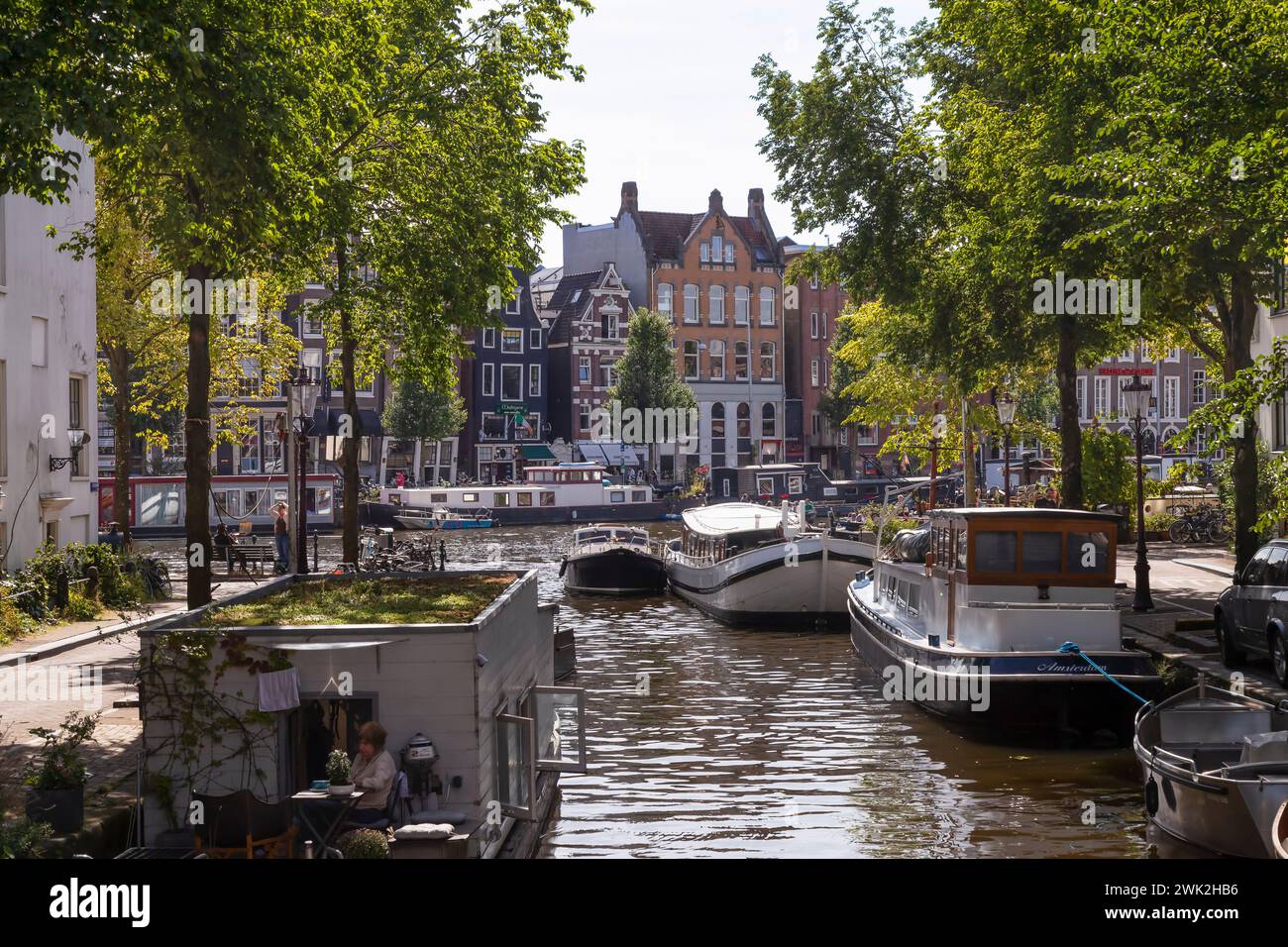 Houseboats and historic canal houses in the lively center of Amsterdam ...