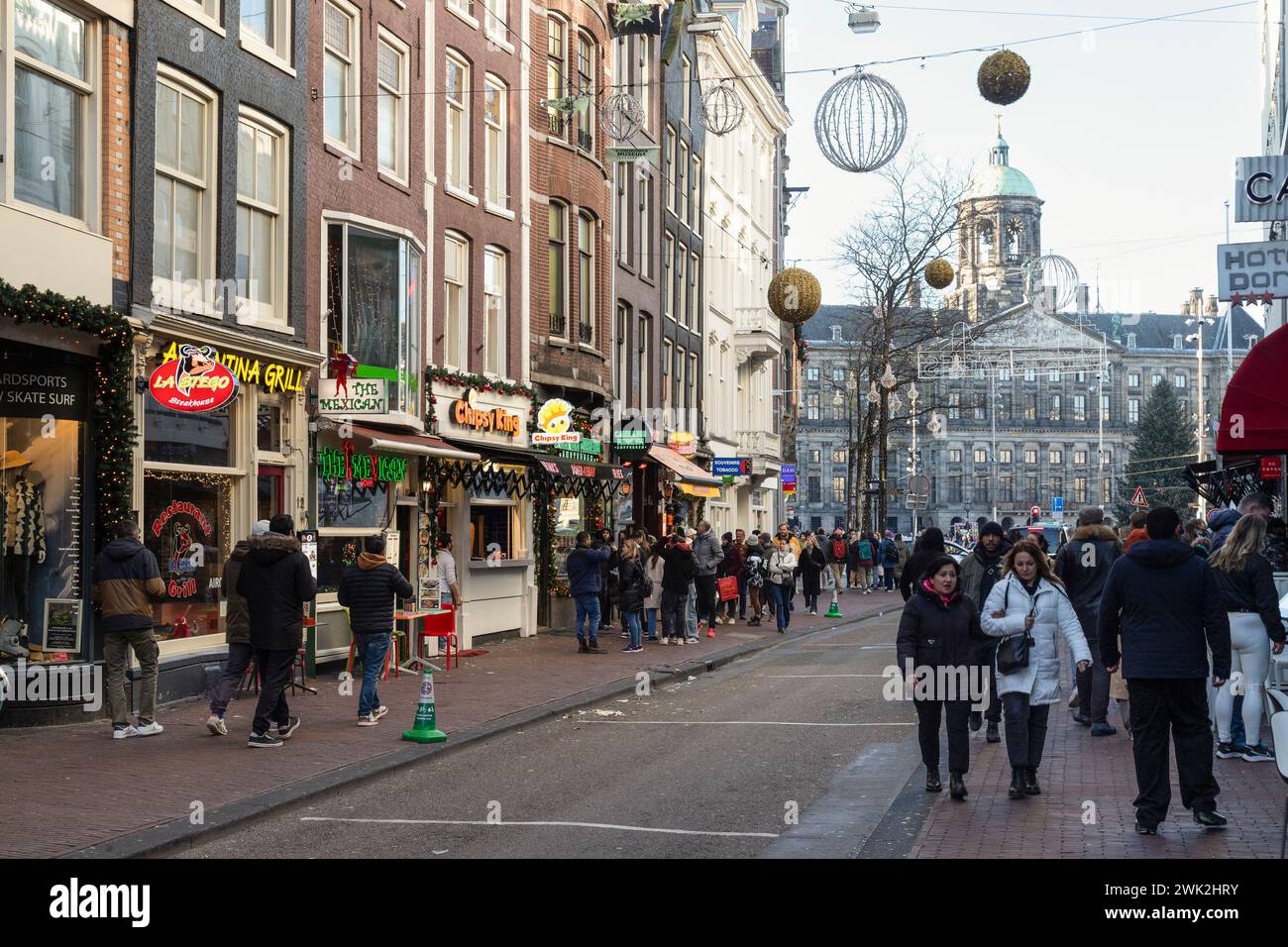 Busy shopping street in Amsterdam with the Royal Palace on Dam Square ...