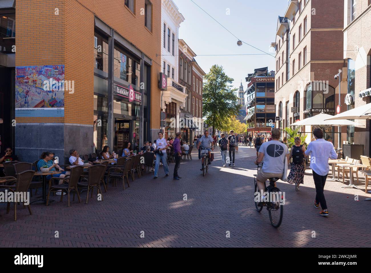 Cozy street in the center of the city of Groningen with the tower of ...