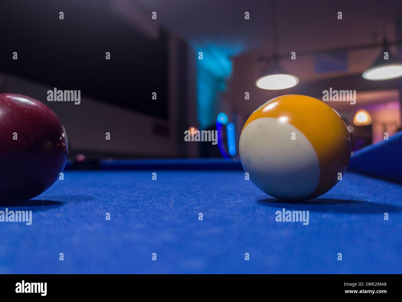 Eight-ball pool game at six pocket blue table. Yellow stripe and solid ...