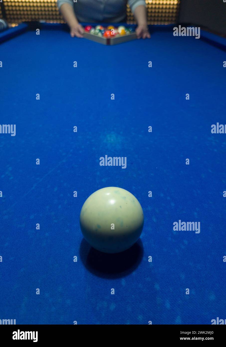 Player racking the balls. Eight-ball pool game at six pocket blue table ...