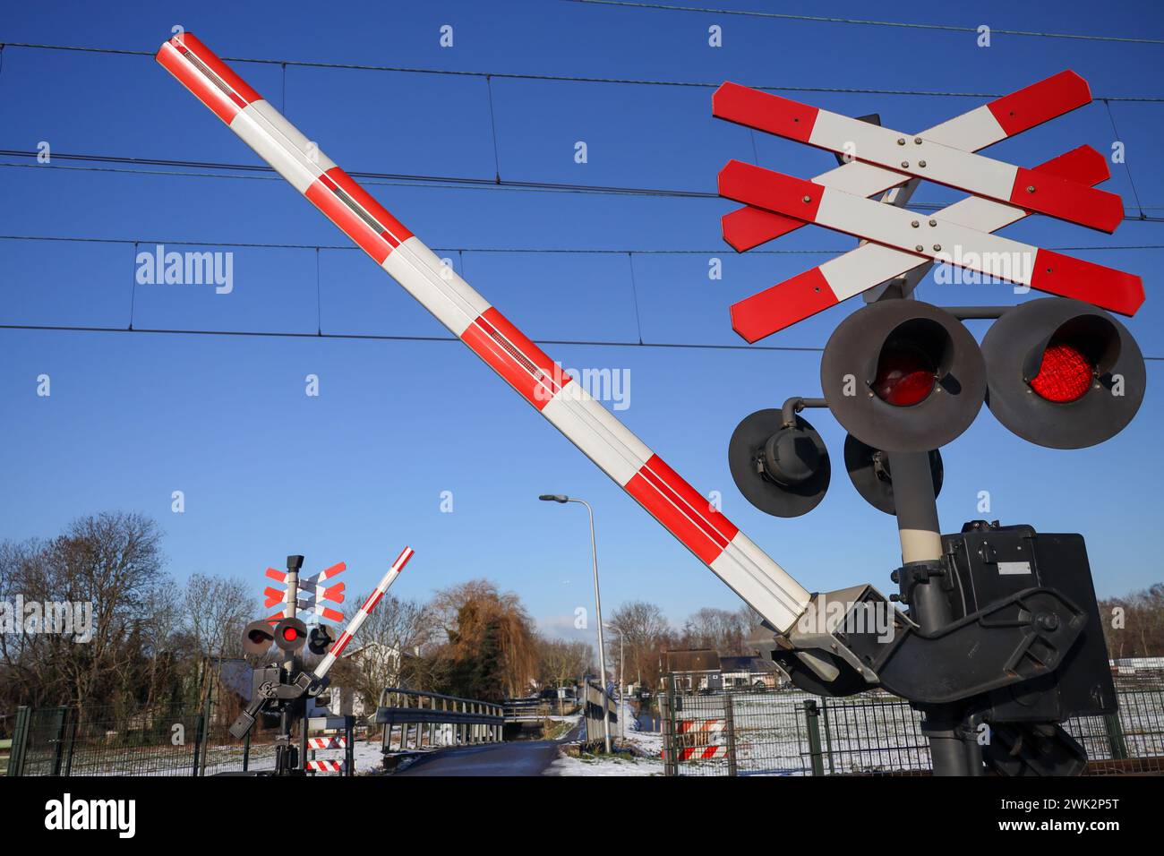 Railway crossing with red lights and barrier in the Zuidplaspolder the ...