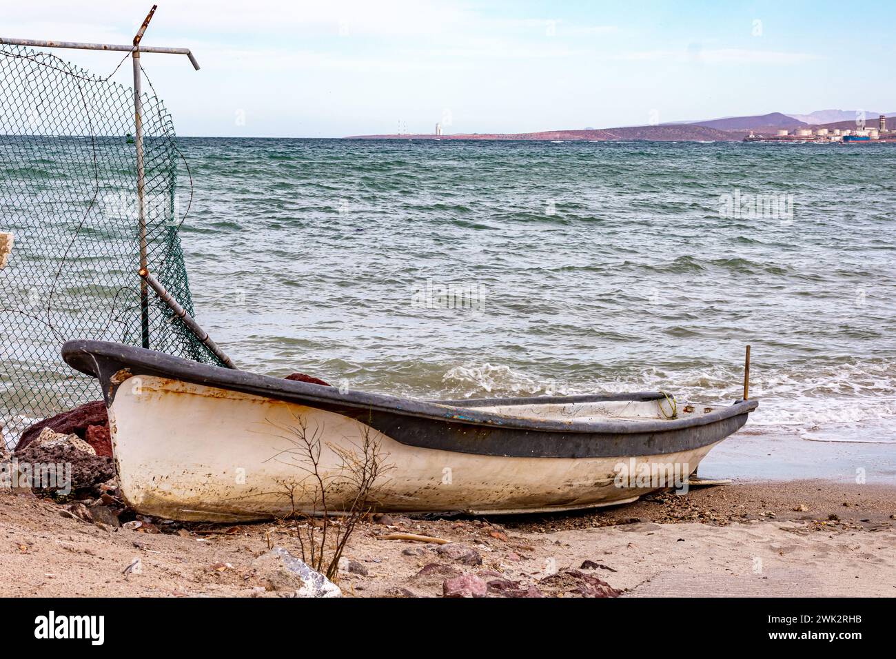 Old rowboat on coastal beach on sand next to metal wire fence, Sea of ...