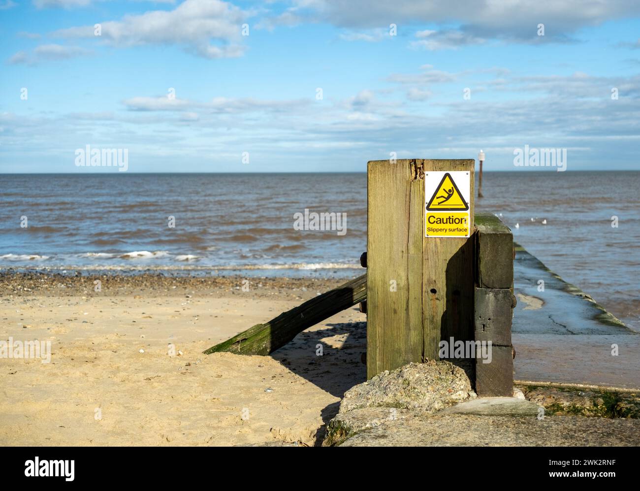 Warning sign on a concrete jetty on Mundesley beach, Norfolk coast ...
