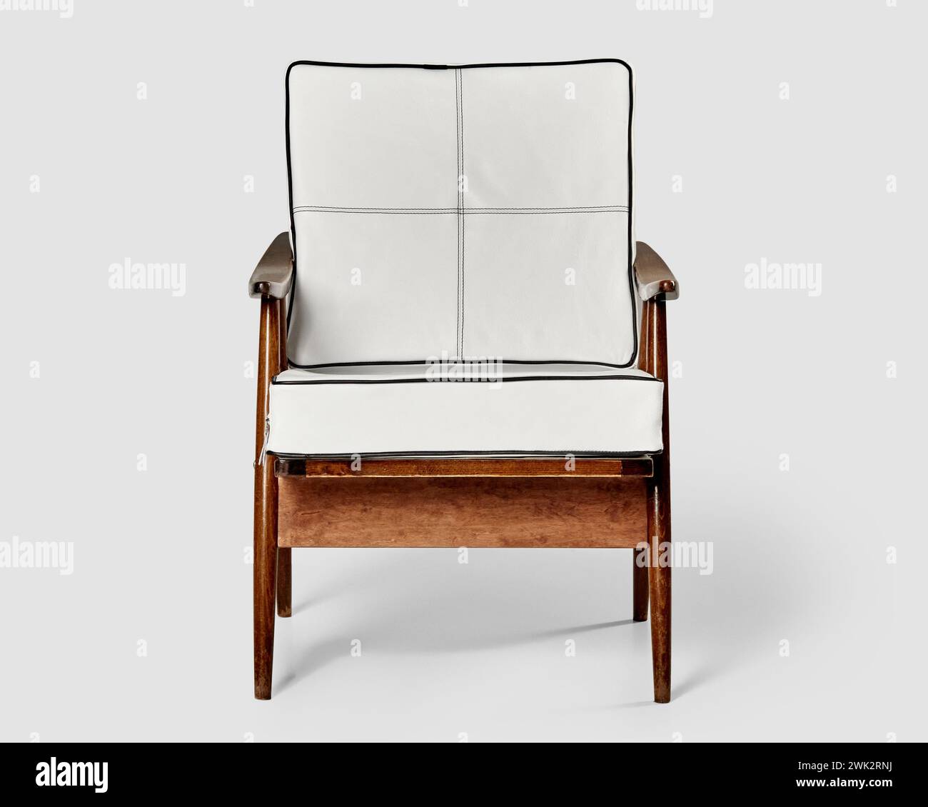 Vintage style chair with white leather cushions and curved wooden arms ...