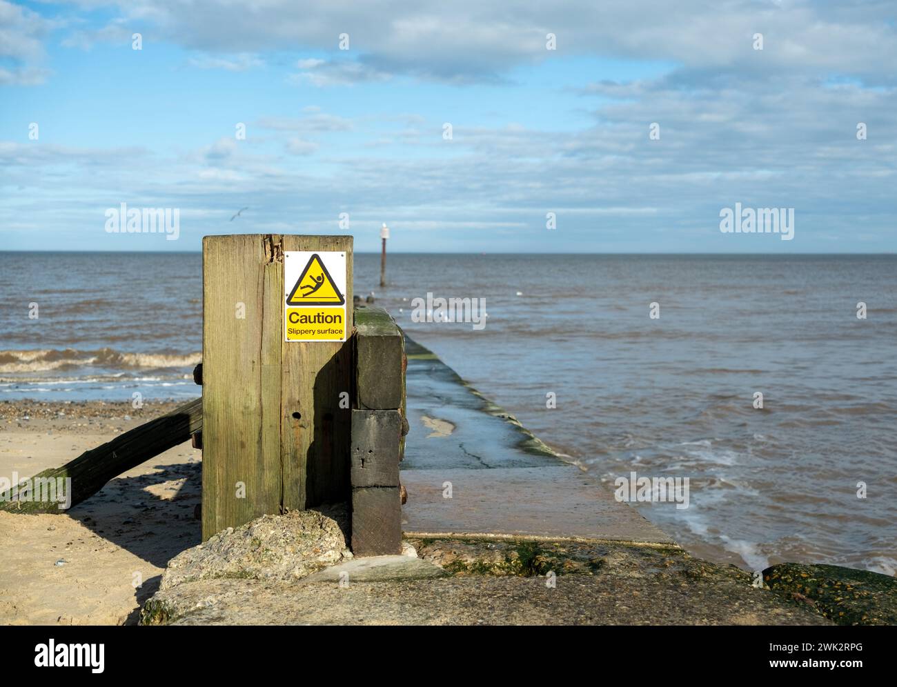 Warning sign on a concrete jetty on Mundesley beach, Norfolk coast ...