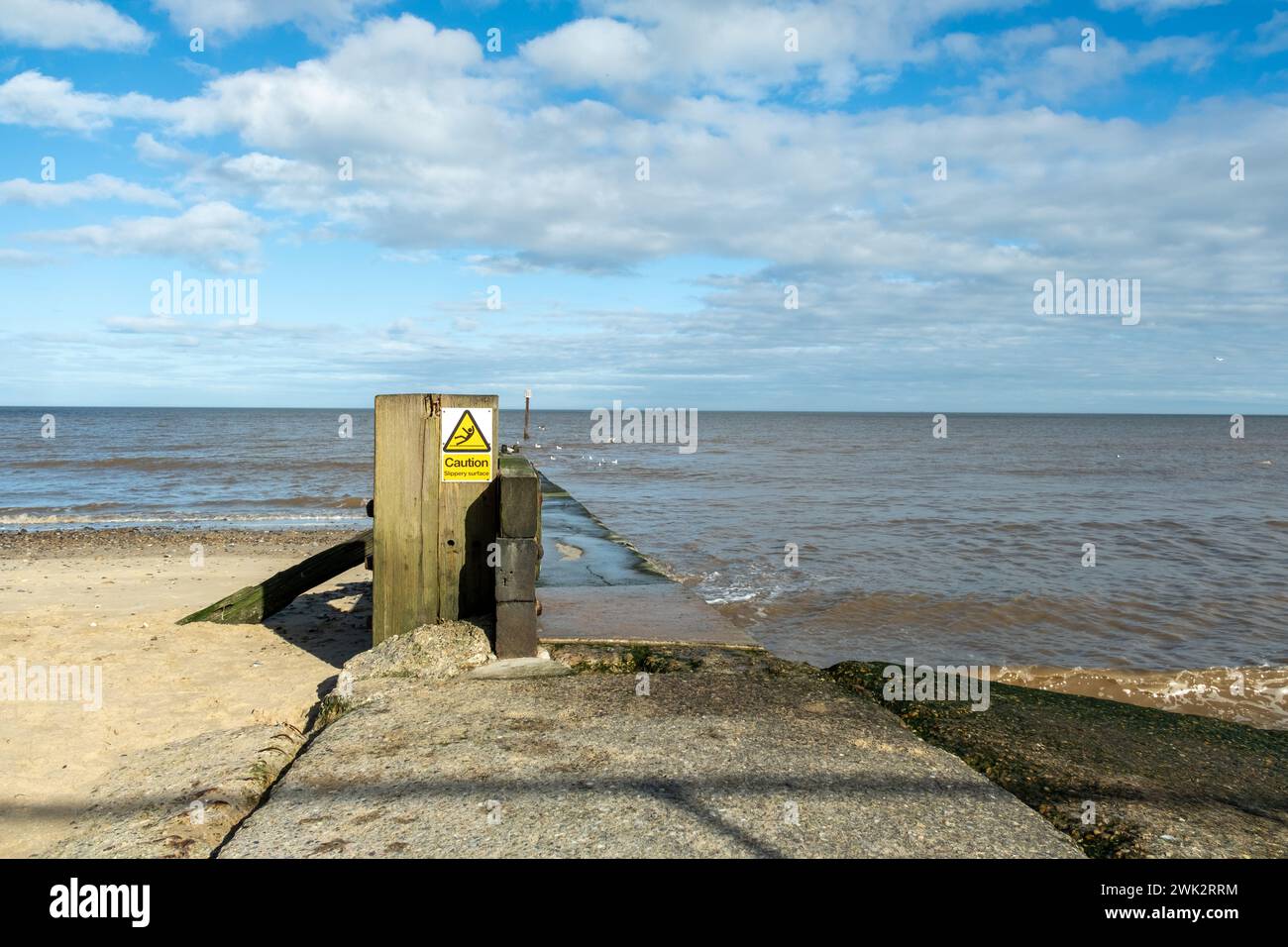 Warning sign on a concrete jetty on Mundesley beach, Norfolk coast ...