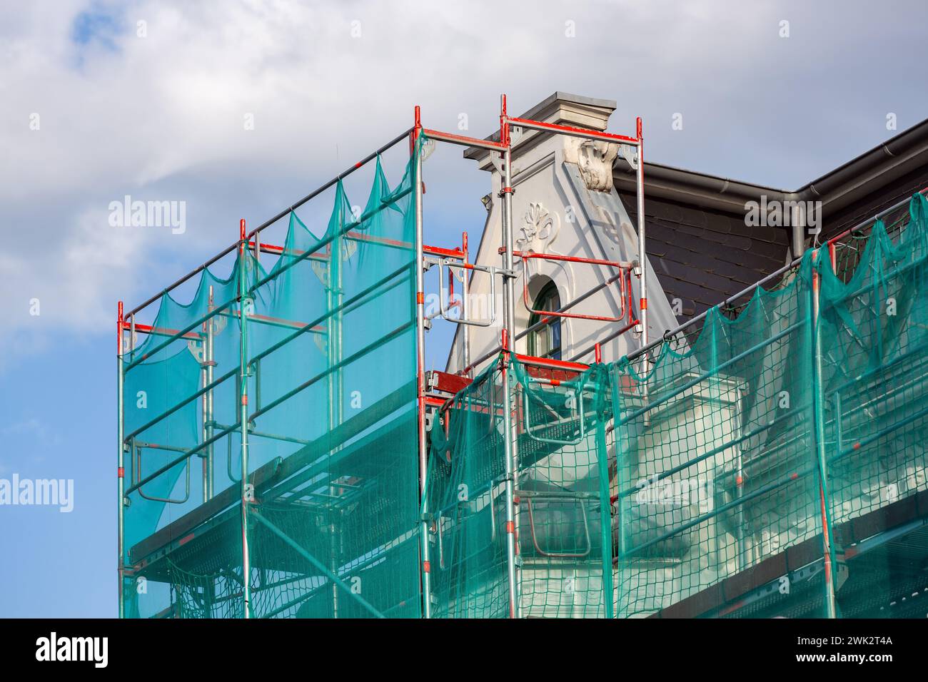 Scaffolding with green net on a city villa with a gable Stock Photo - Alamy