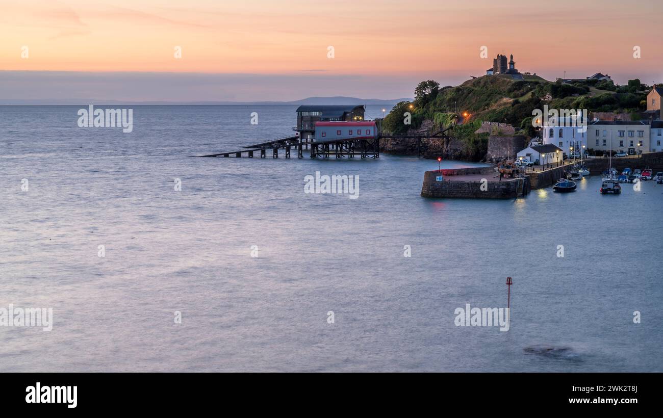 Tenby harbour and lifeboat station, at sunrise on a calm summers day ...
