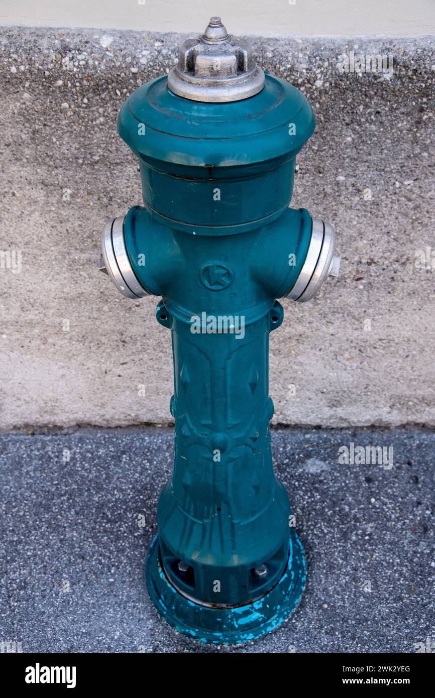 A green hydrant with two tapping points and a tap on the top in front ...