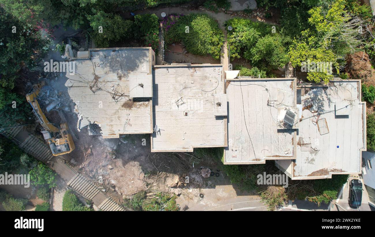 Excavator demolishing barracks for a new construction project. Aerial ...