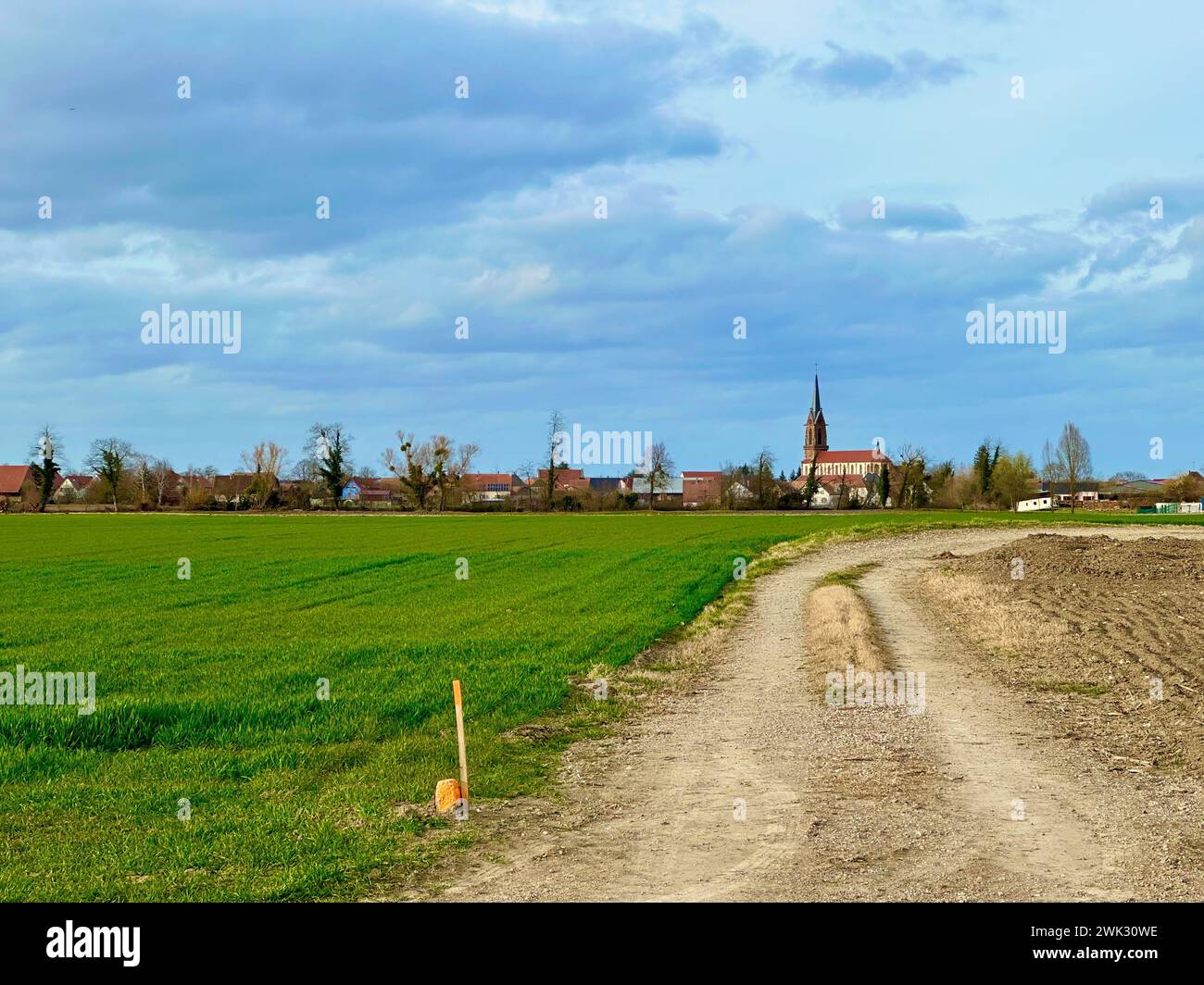 Rustic Trail Leading to a Quaint Village with a Stately Church in the ...