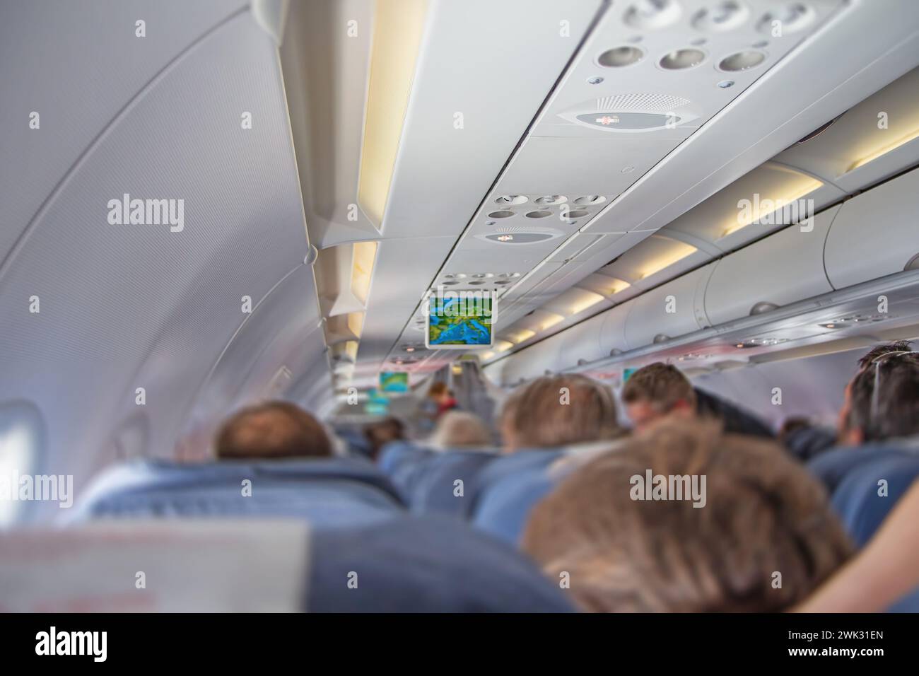 Rear view of the interior of the plane filled with tourists sitting on ...