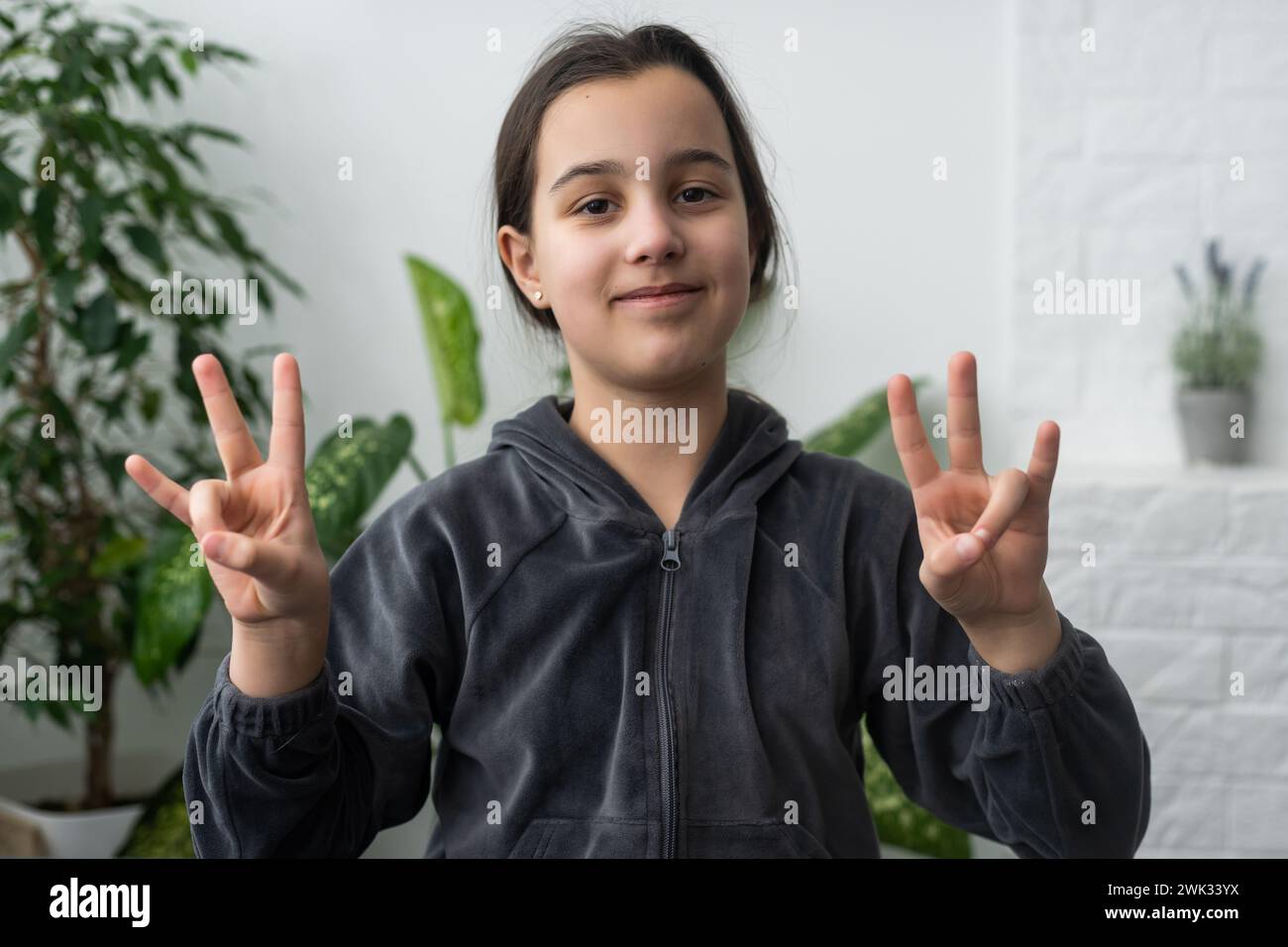 Beautiful smiling deaf girl using sign language Stock Photo - Alamy