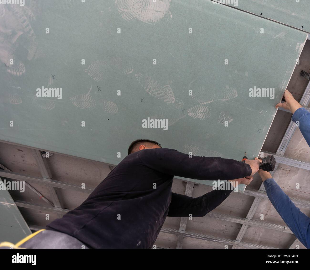 Workers fitting panel into frame of ceiling Stock Photo - Alamy