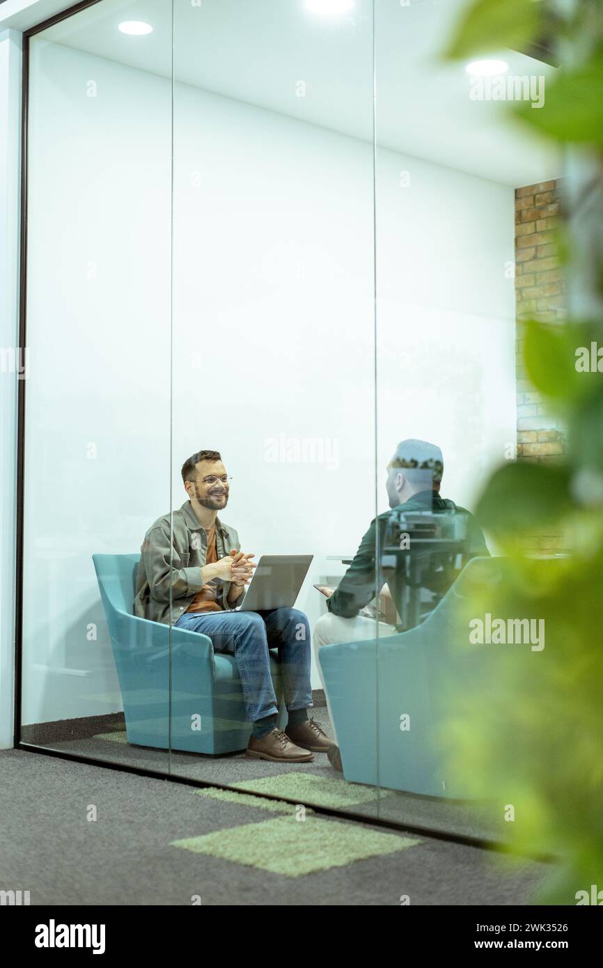 Two professionals engage in a conversation while seated comfortably in ...