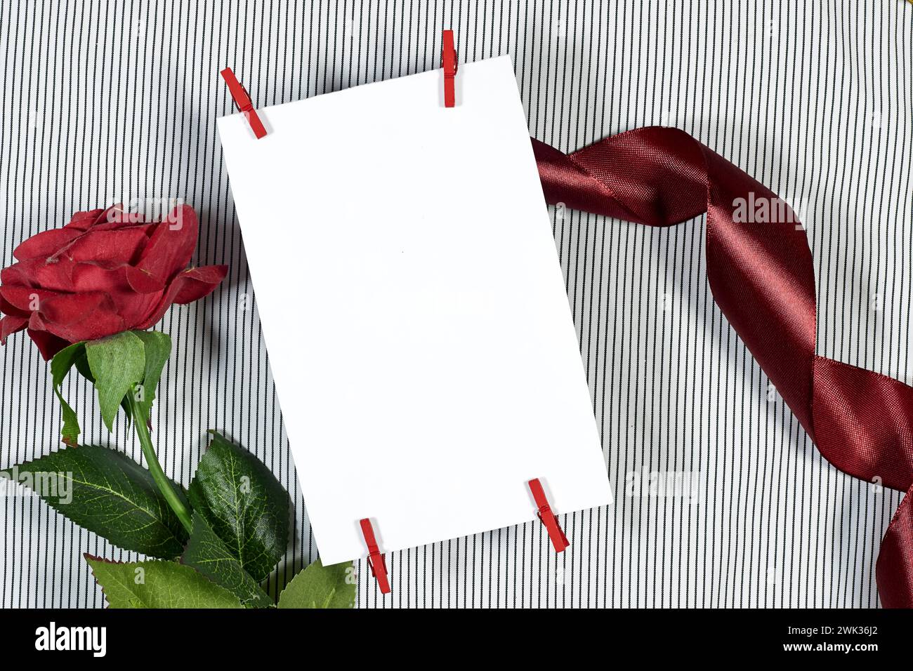 Blank greeting card, flyer or invitation card mockup with red peg, rose ...