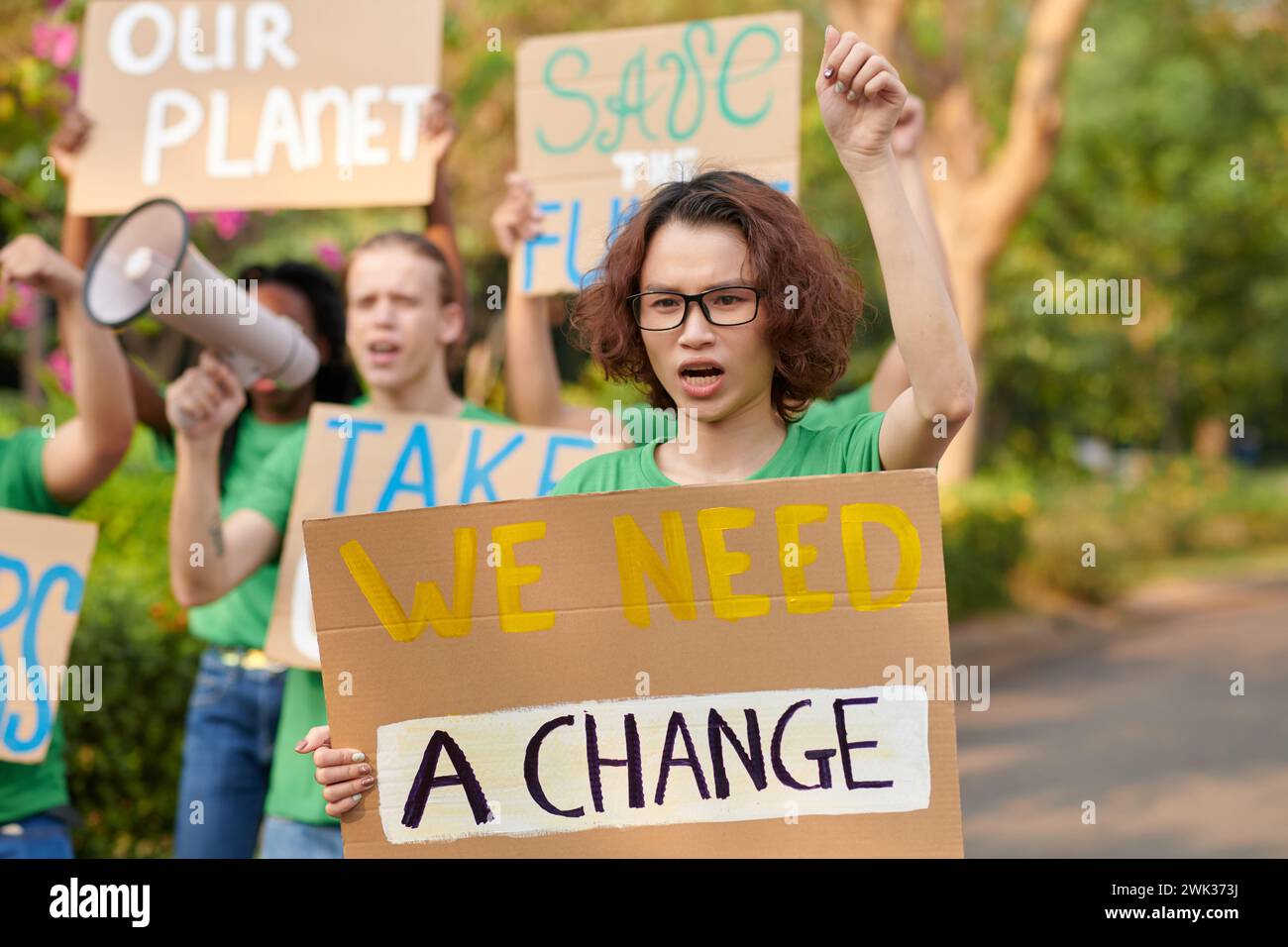 Eco activist shouting when taking part in protest, walking with placard ...