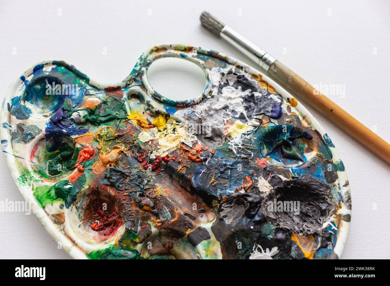 Palette with bright colours with paintbrush on white background ...