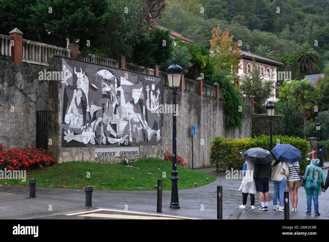 people view the tiled mural of the painting Guernica by Pablo Picasso ...