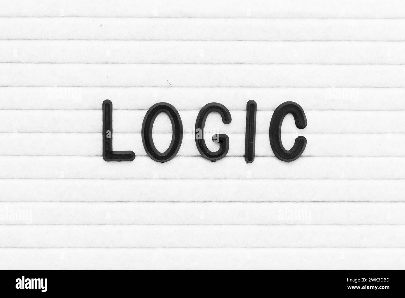 Black color letter in word logic on white felt board background Stock ...