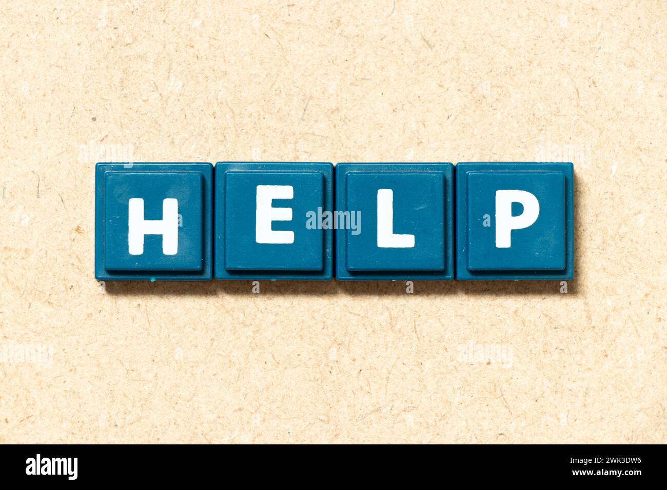 Tile alphabet letter in word help on wood background Stock Photo - Alamy