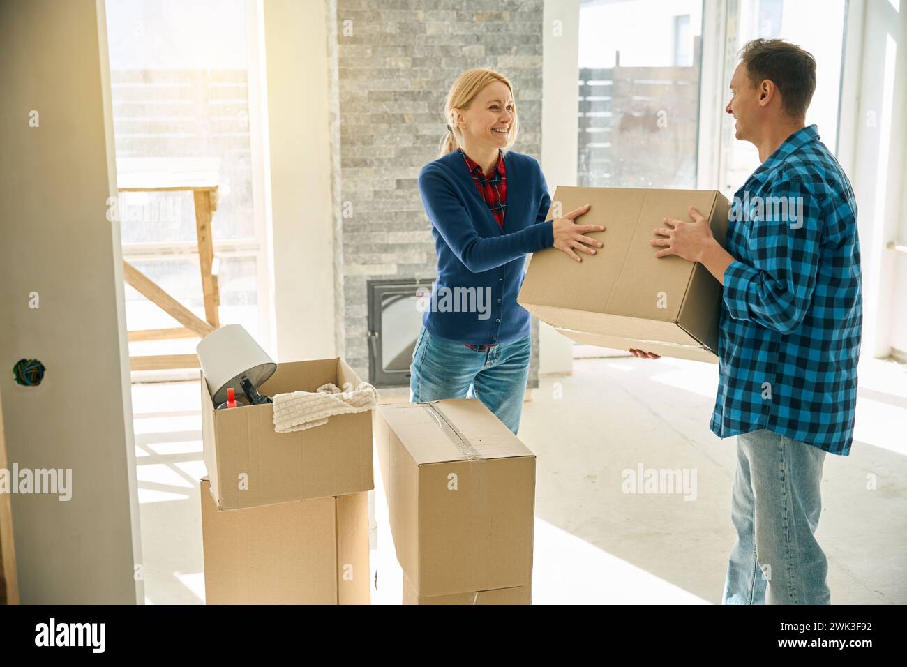 Happy couple arranging boxes after moving to new house Stock Photo - Alamy