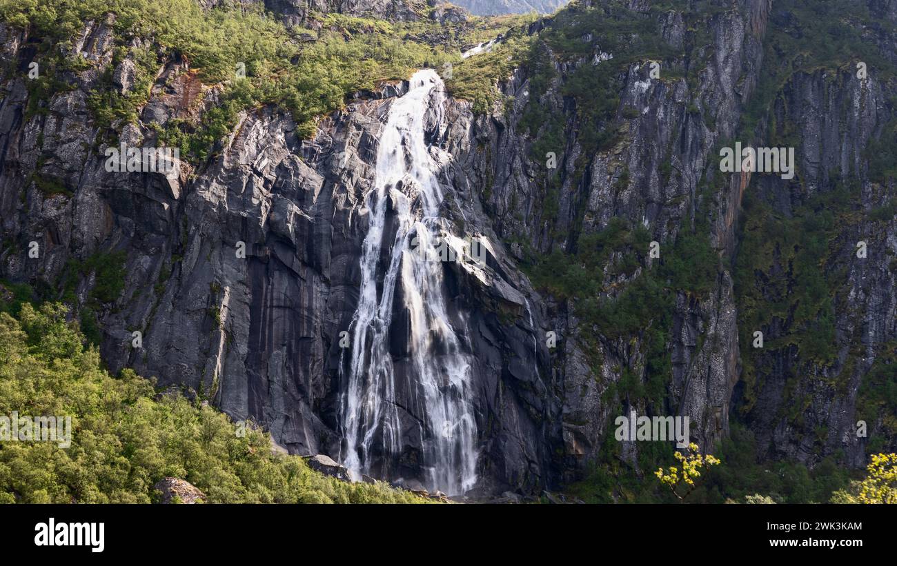 The Valefossen waterfall cascades over stark cliffs amidst the verdant ...