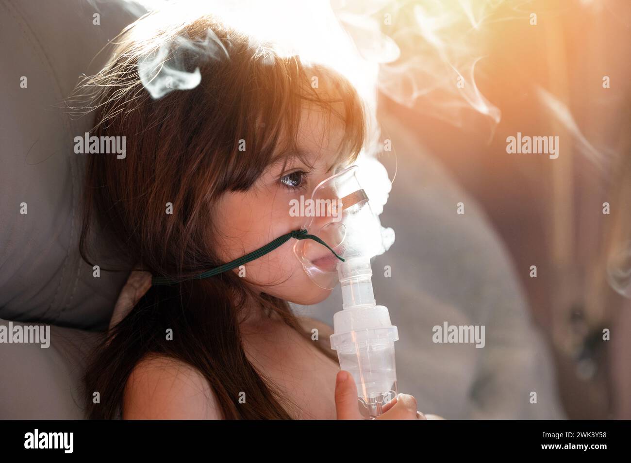 Caucasian girl kid with inhaler mask using at home in steam sunny ...