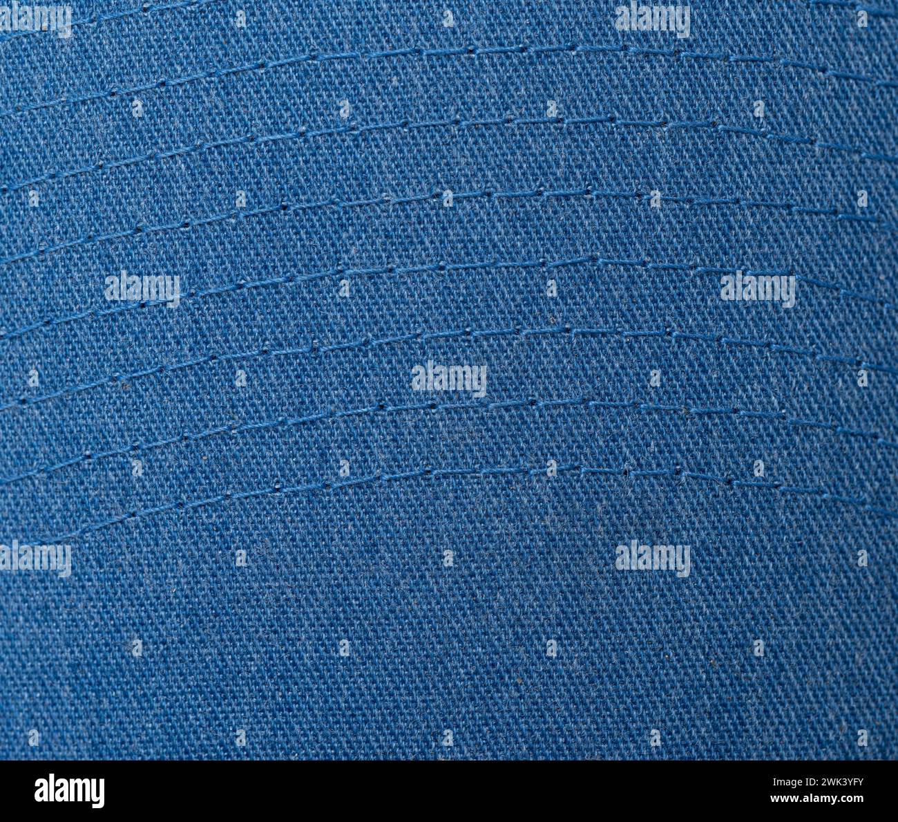 Denim material with stitches blue color background close up view Stock ...