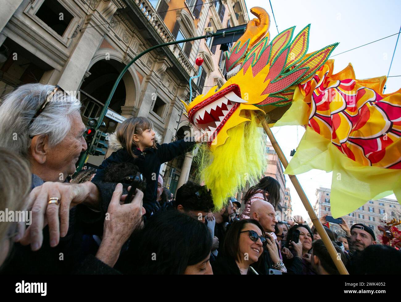 Rome, Italy. 18th Feb, 2024. A girl interacts with a dragon dance prop ...
