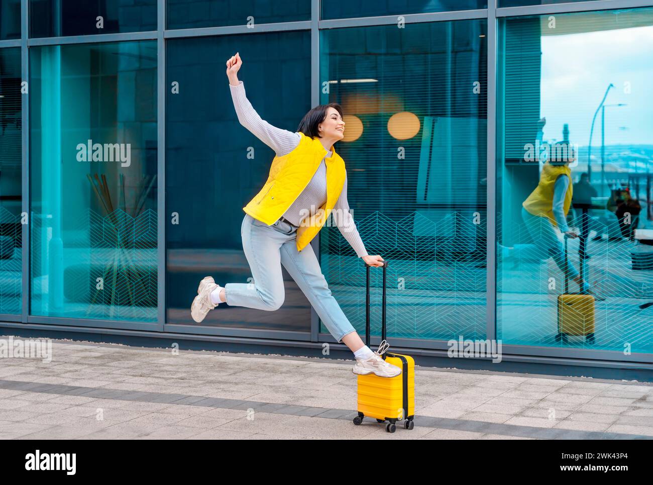 engoing woman jumping holding suitcase. woman enjoys vacation Passenger ...