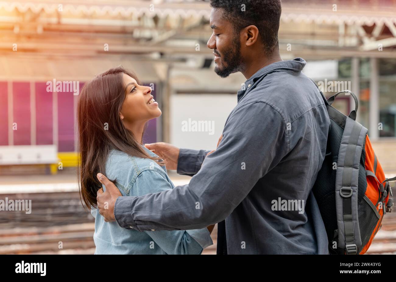 a young beautiful couple embraces on the platform meeting, saying goodbye the spouse, friend ...