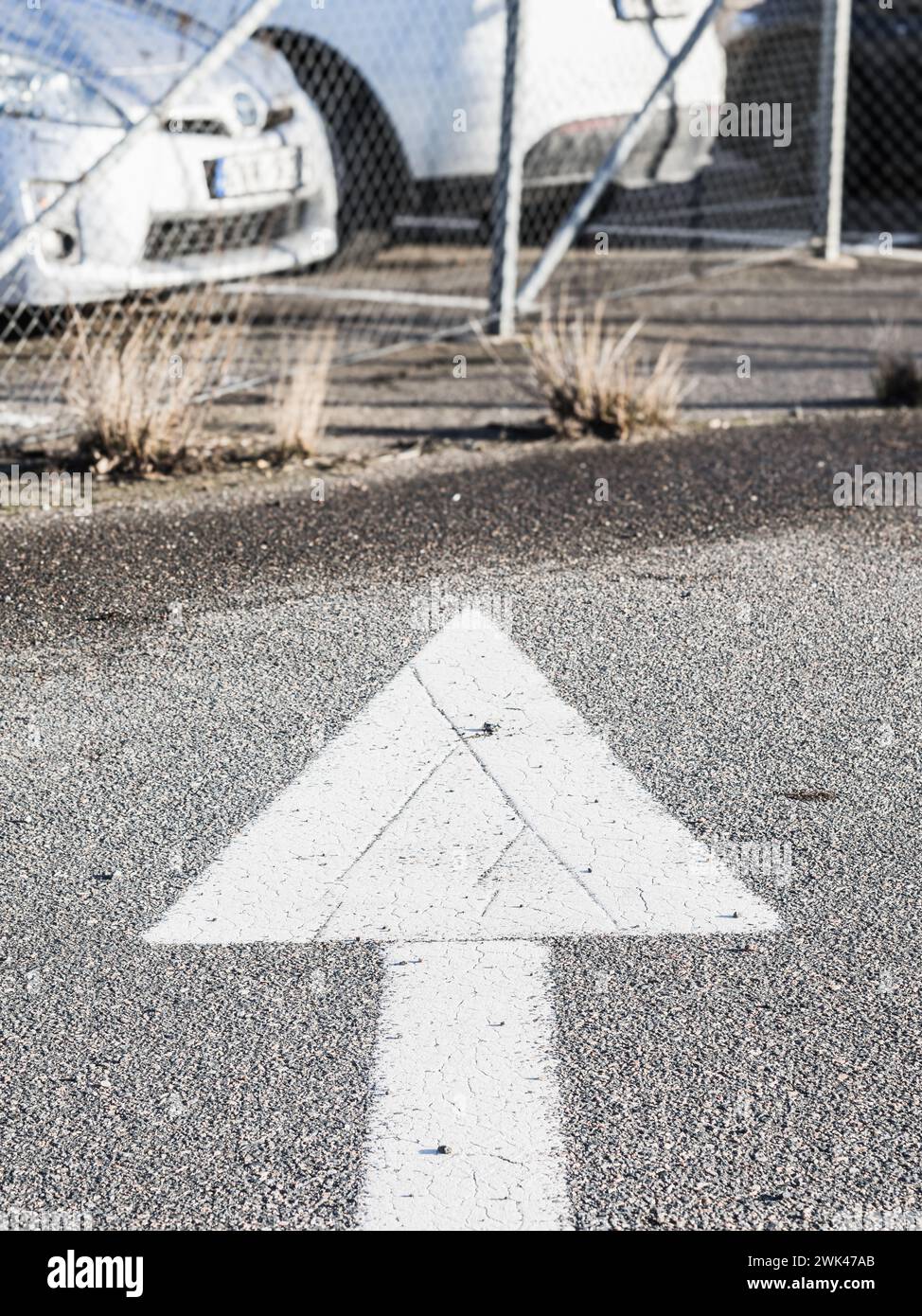 This image captures a stark white directional arrow indicating forward ...