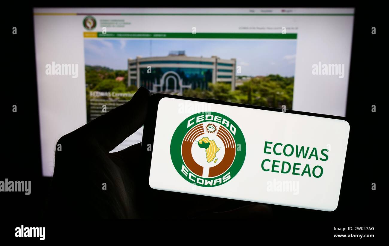 Person holding smartphone with logo of Economic Community of West ...