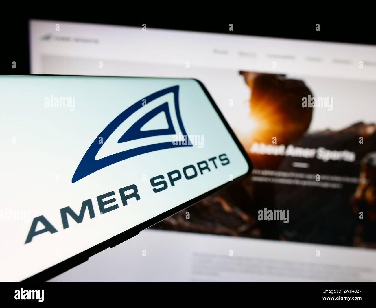 Smartphone with logo of Finnish sporting equipment company Amer Sports Oyj in front of business ...