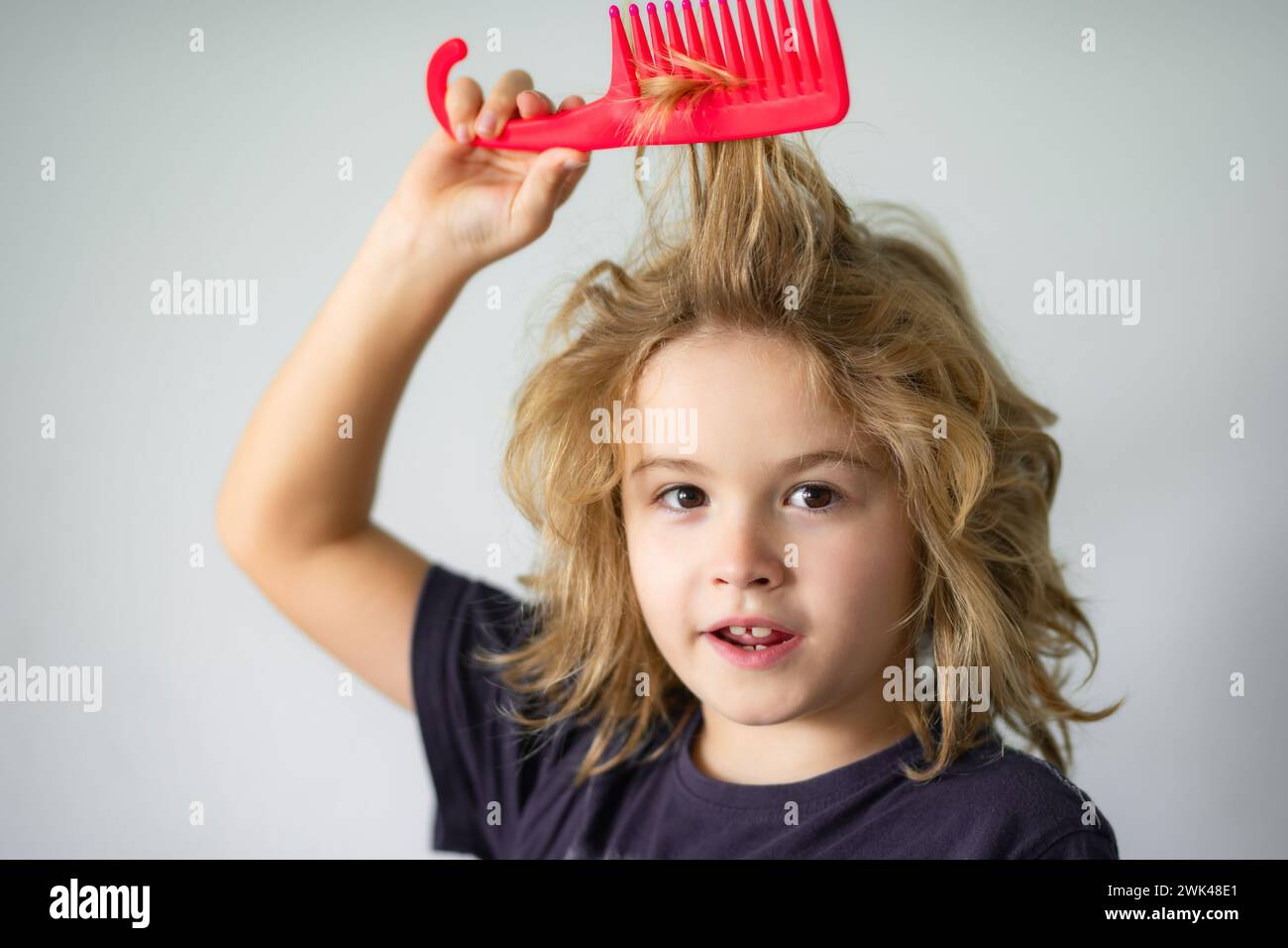 Daily hair care routine. Little kid combing hair, isolated studio ...