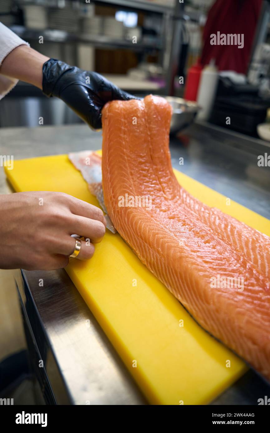 Man cuts red fish with a sharp knife Stock Photo - Alamy