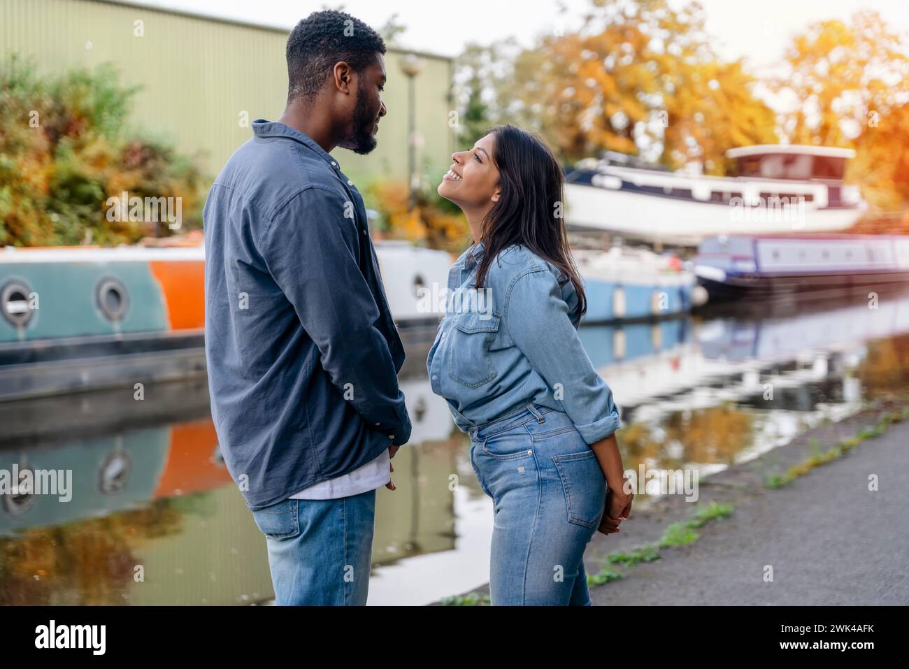 A handsome man flirting with a beautiful smiling woman as they walk ...