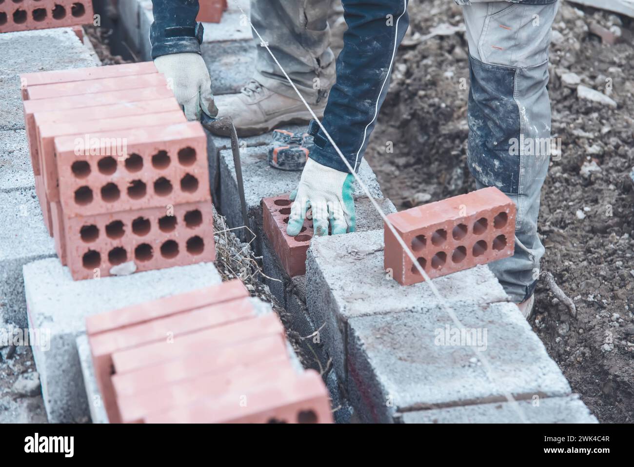 Bricklayer laying brick on cement mix on construction site close-up ...