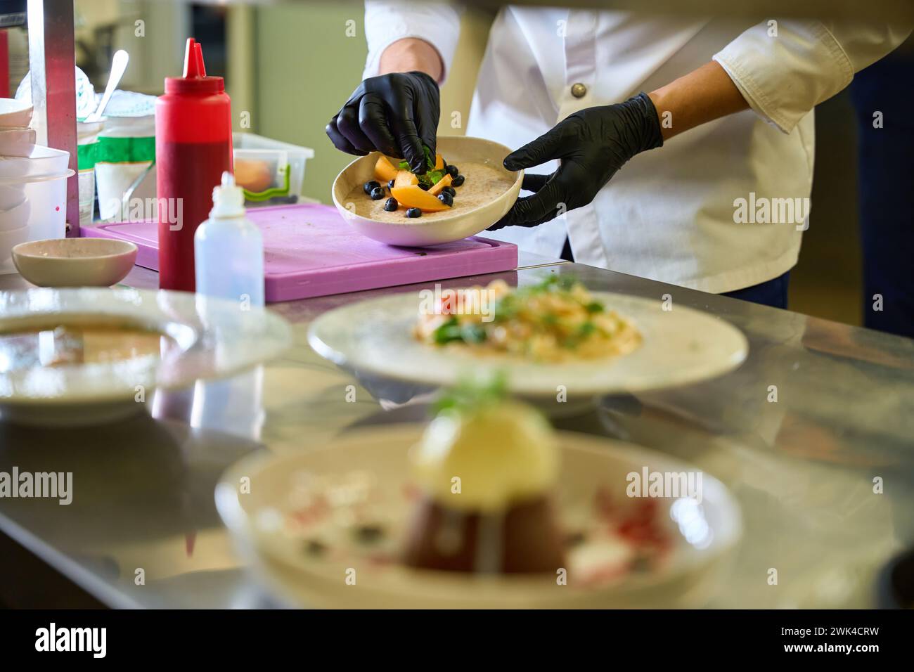Chef decorates ready-made dishes for serving Stock Photo - Alamy