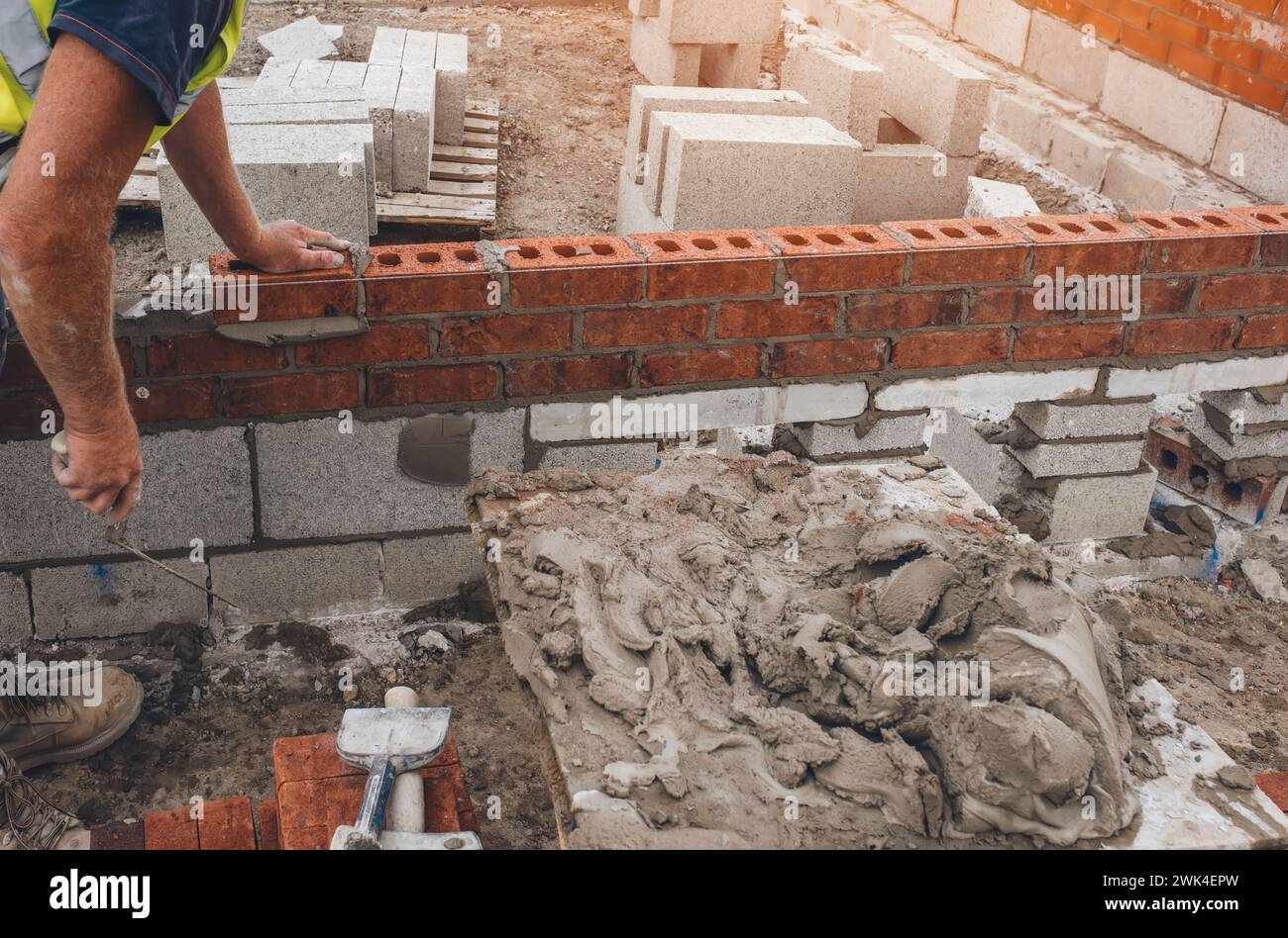 Bricklayer laying brick on cement mix on construction site close-up ...