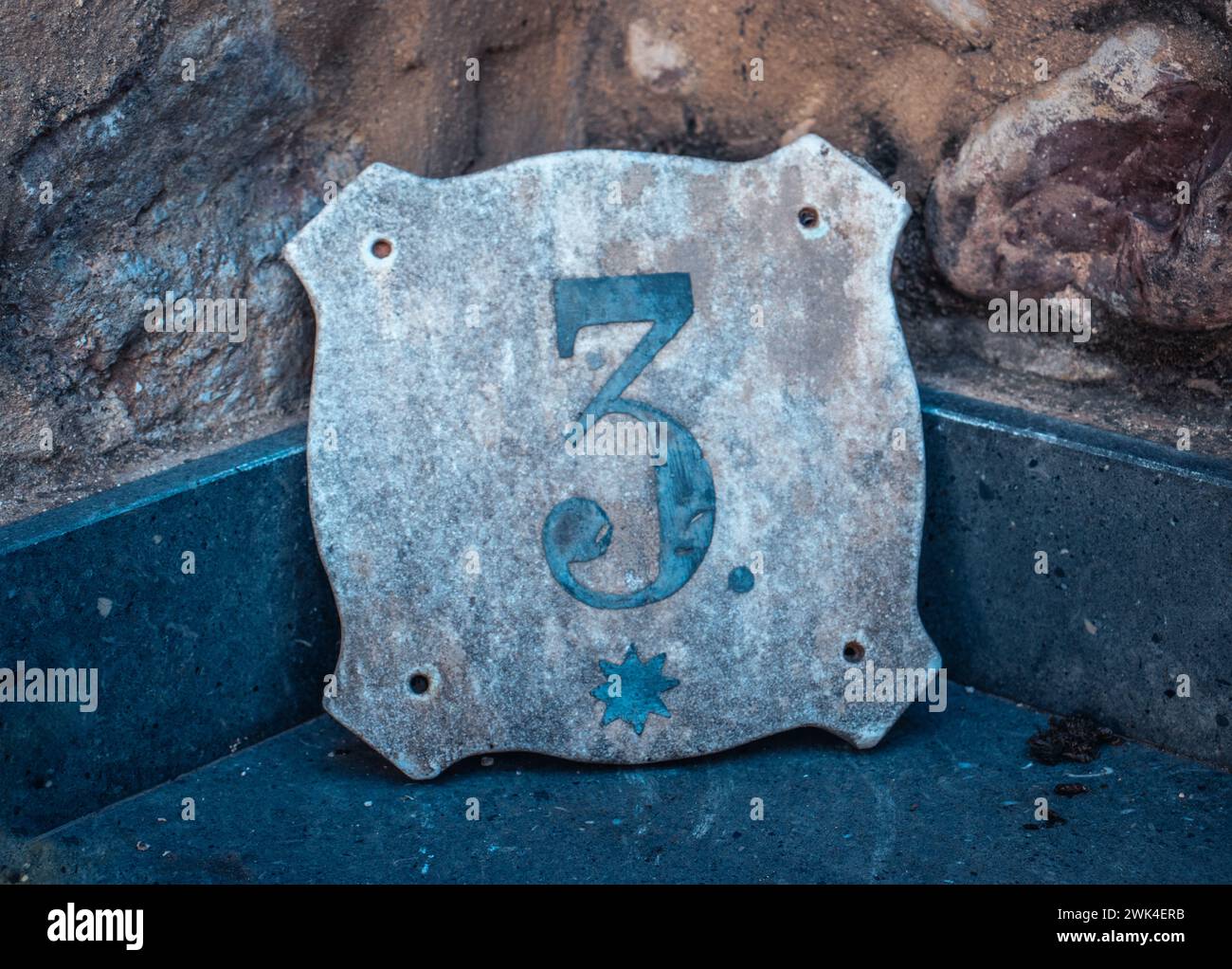 Gray house number plate in Catalonia. Street sign number 3 on old ...