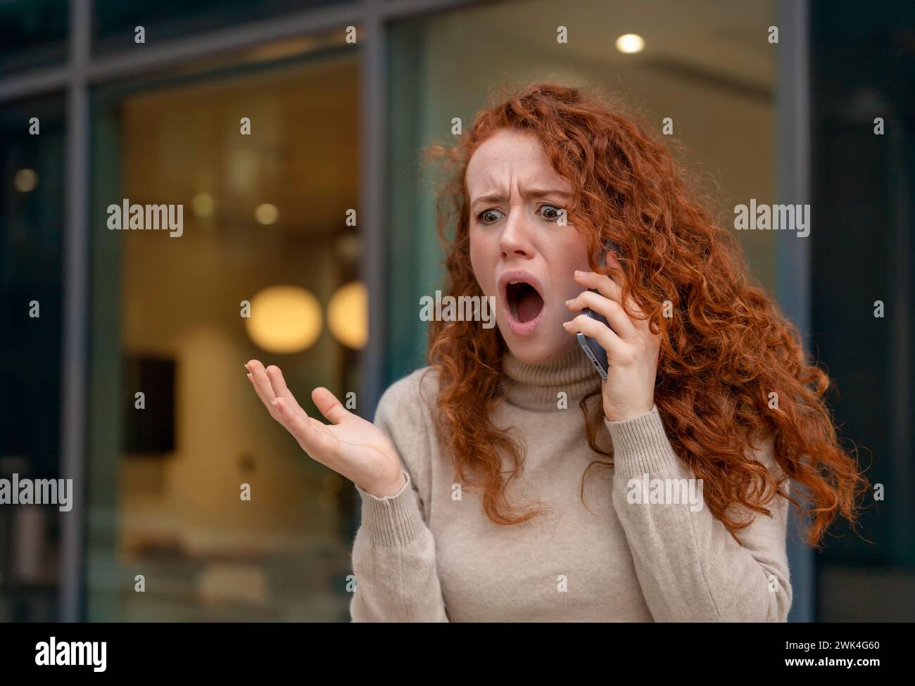 Portrait of a young woman talking in anger on her mobile to her ...