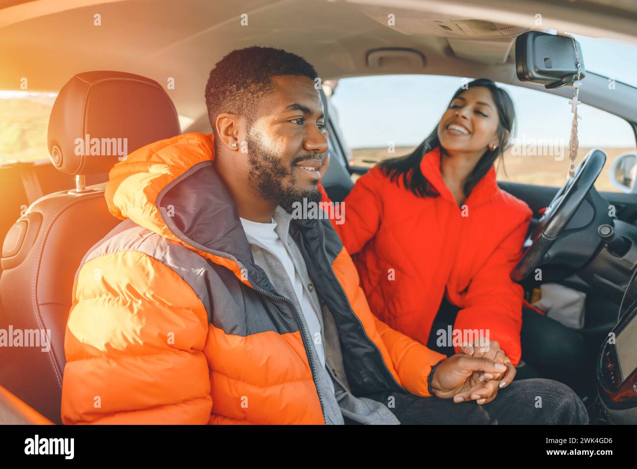 Beautiful happy young loving couple holding hands and smiling while ...