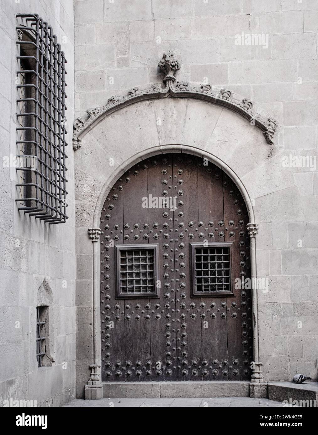 Wooden door with iron fittings in Gothic Quarter street in Catalonia. A ...
