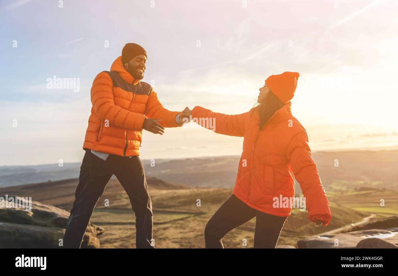 Happy couple in love walking on a rocks on the mountain trail at cold ...